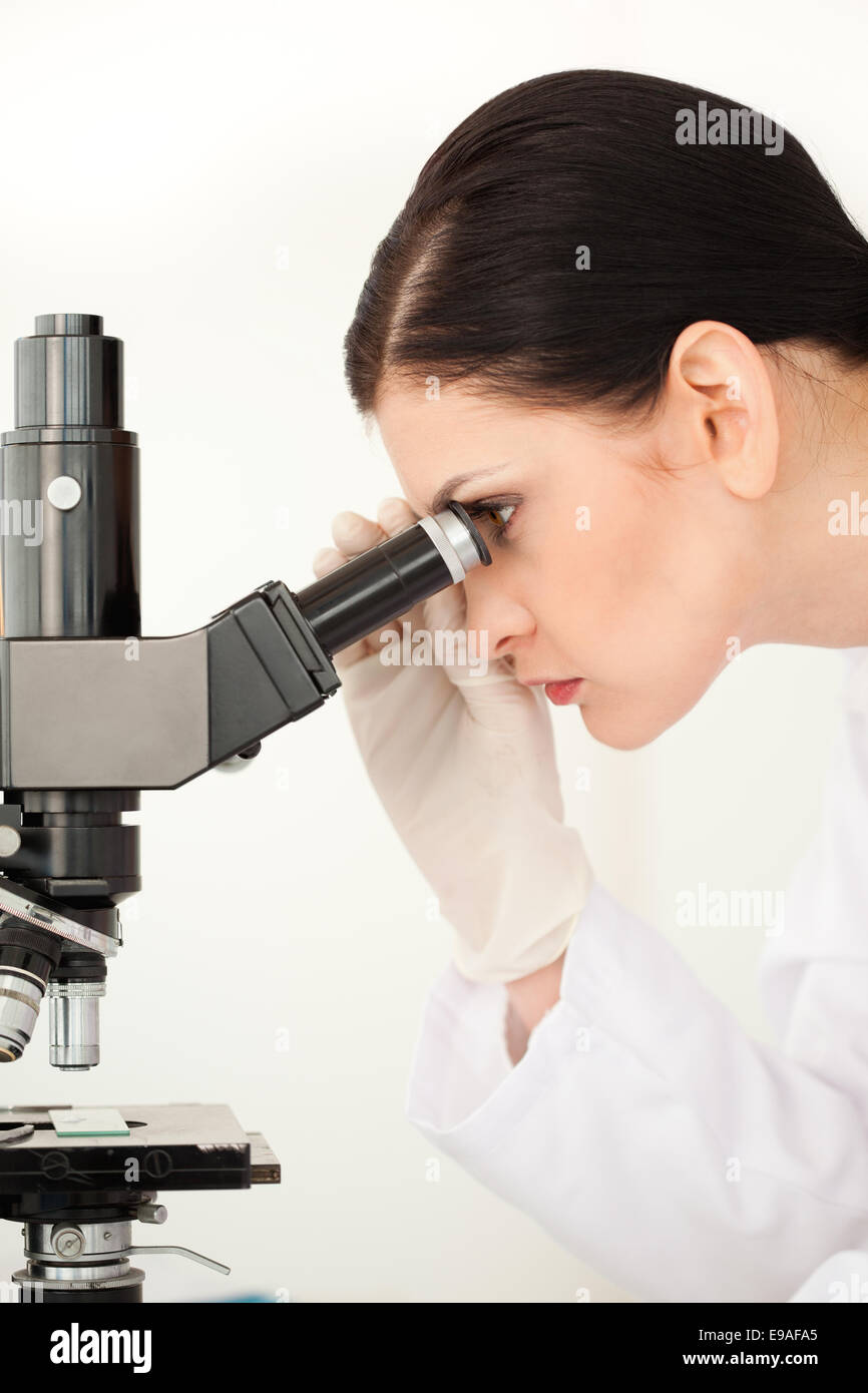 Female scientist looking through a microscope Stock Photo - Alamy