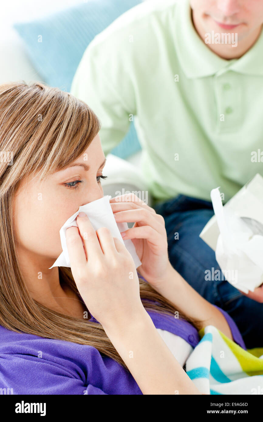 Sick woman with tissue lying on a sofa Stock Photo - Alamy