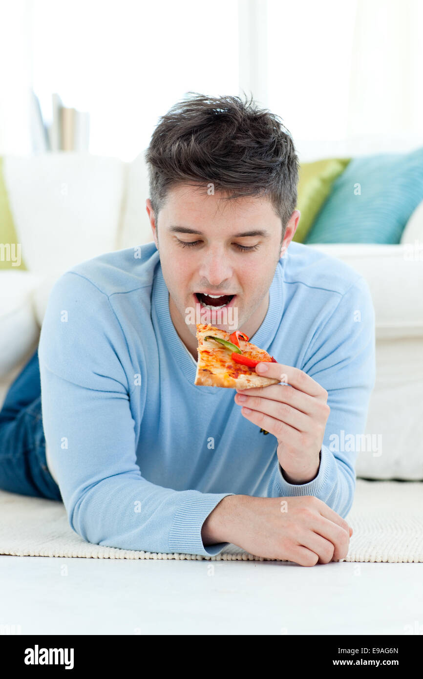 A young man eating pizza Stock Photo - Alamy