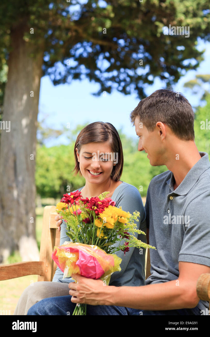 Young man offering flowers to his girlfriend Stock Photo - Alamy