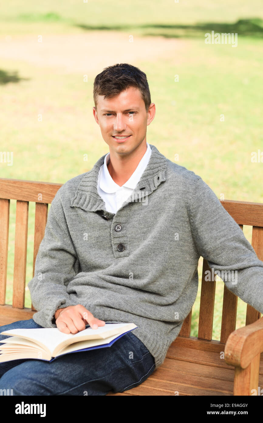 Man reading his book on the bench Stock Photo - Alamy