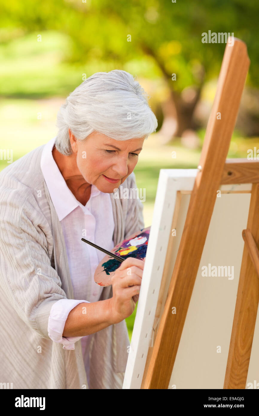 Mature woman painting in the park Stock Photo - Alamy
