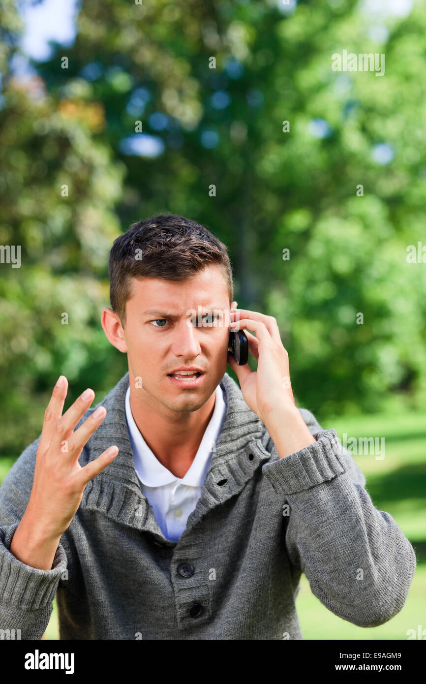 Young man phoning on the bench Stock Photo - Alamy