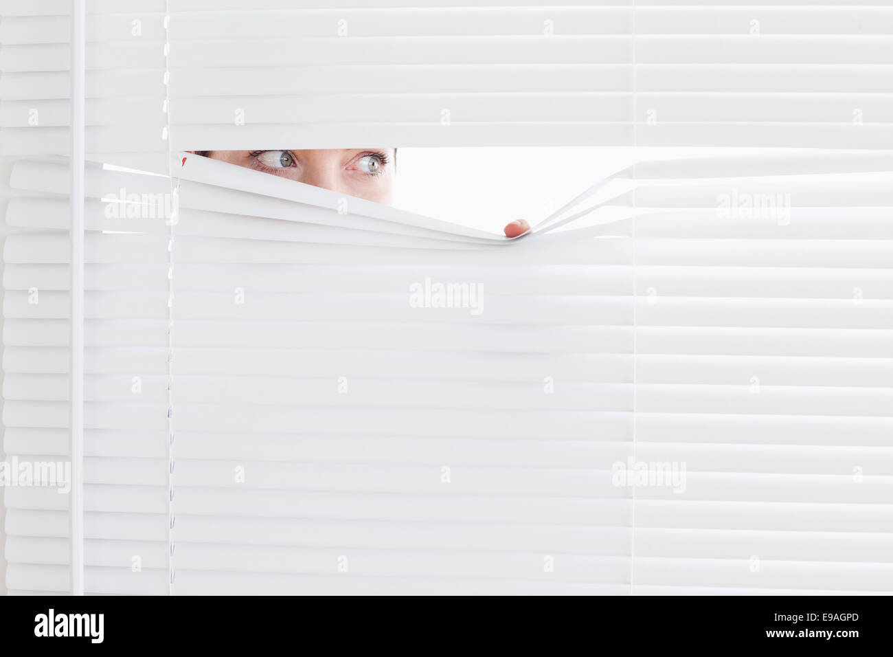 Businesswoman peeking out of a window Stock Photo - Alamy