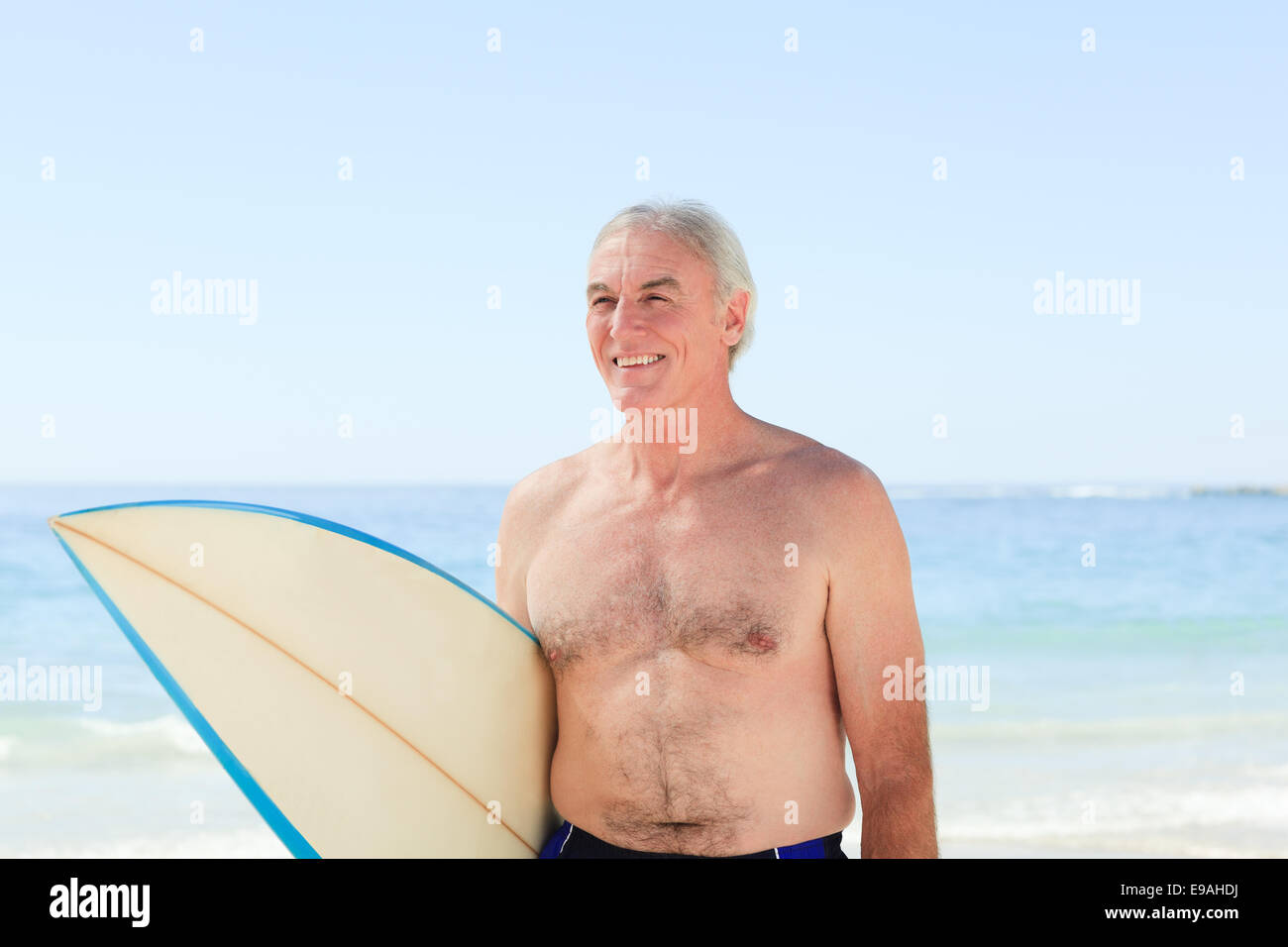 Retired man with his surfboard Stock Photo - Alamy