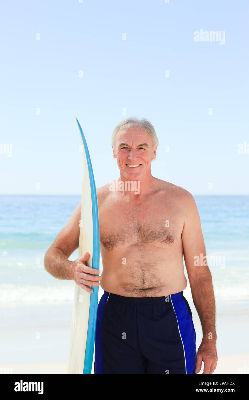 Retired man with his surfboard Stock Photo - Alamy