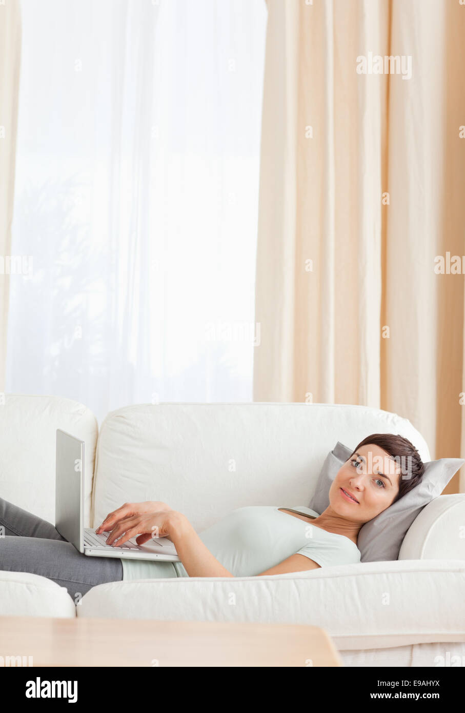 Portrait of a woman relaxing with a laptop Stock Photo - Alamy