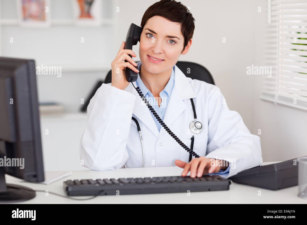 Smiling female doctor making a phone call Stock Photo - Alamy