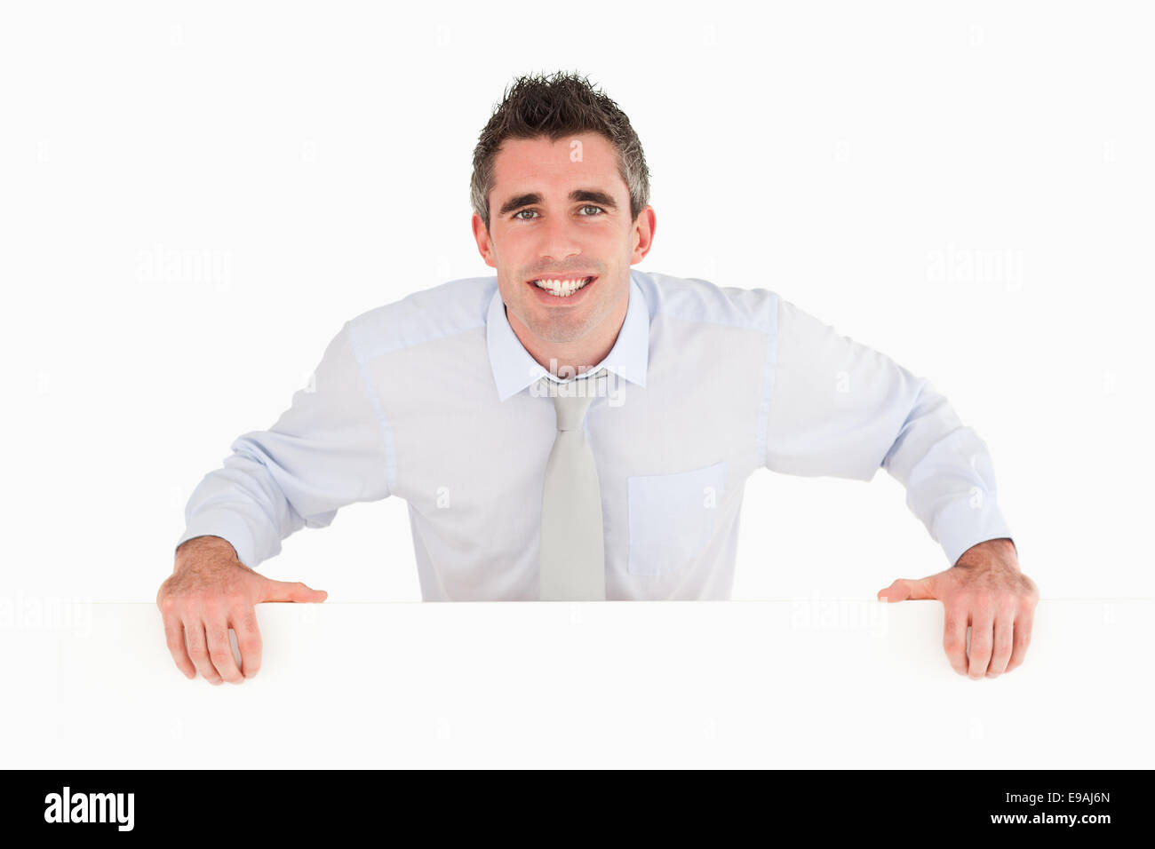 Young man standing behind board Cut Out Stock Images & Pictures - Alamy