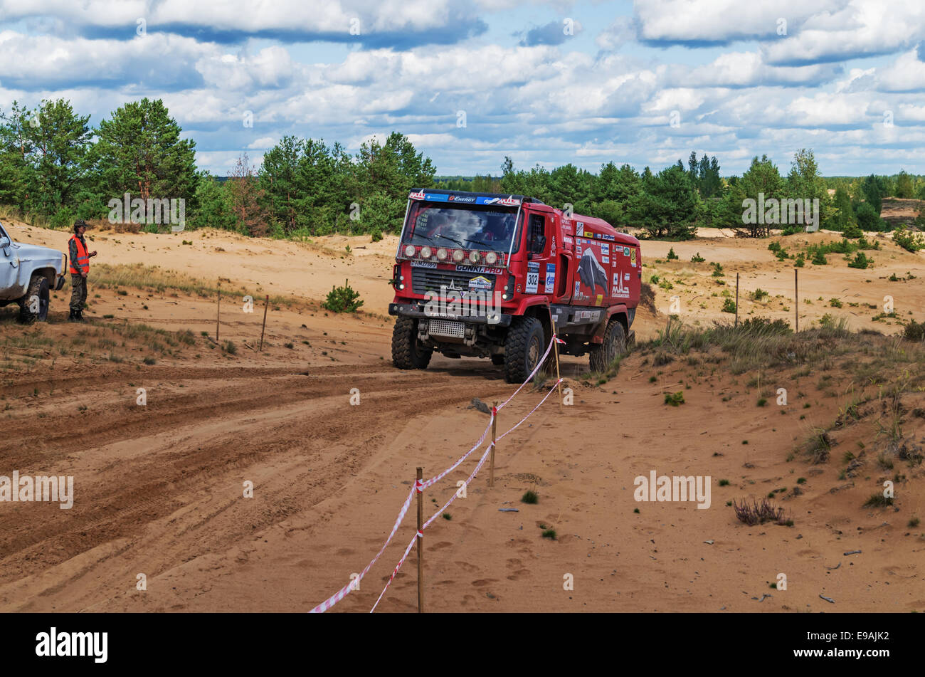 Races on a rally-raid on sandy dunes. Racing truck maz number 302 Stock ...