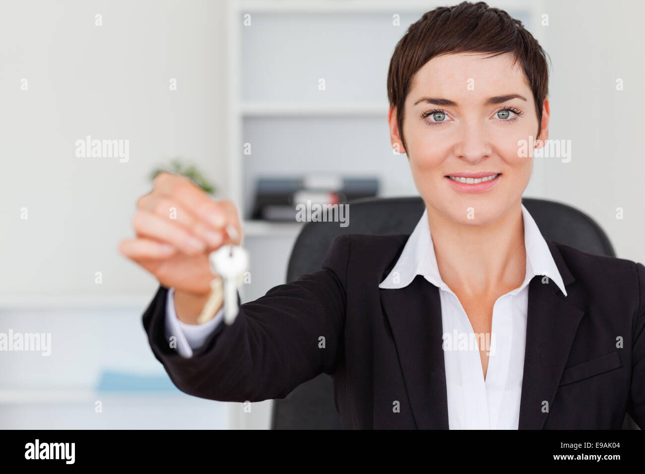 Smiling secretary showing keys Stock Photo - Alamy