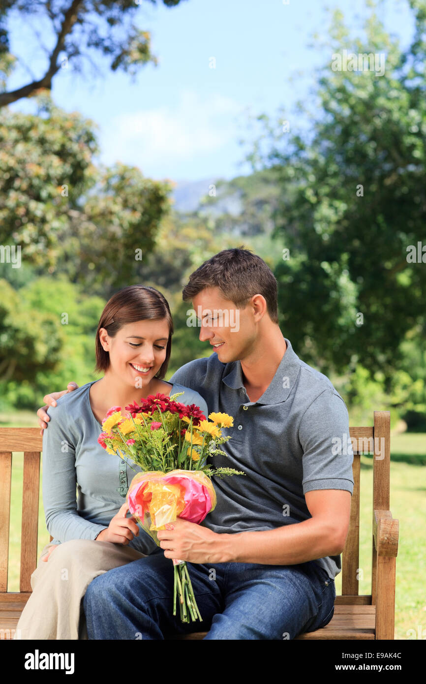 Man offering flowers to his girlfriend Stock Photo - Alamy