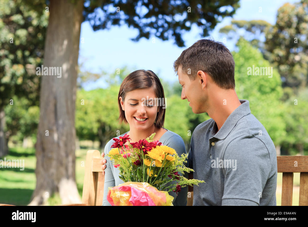 Young man offering flowers to his girlfriend Stock Photo - Alamy