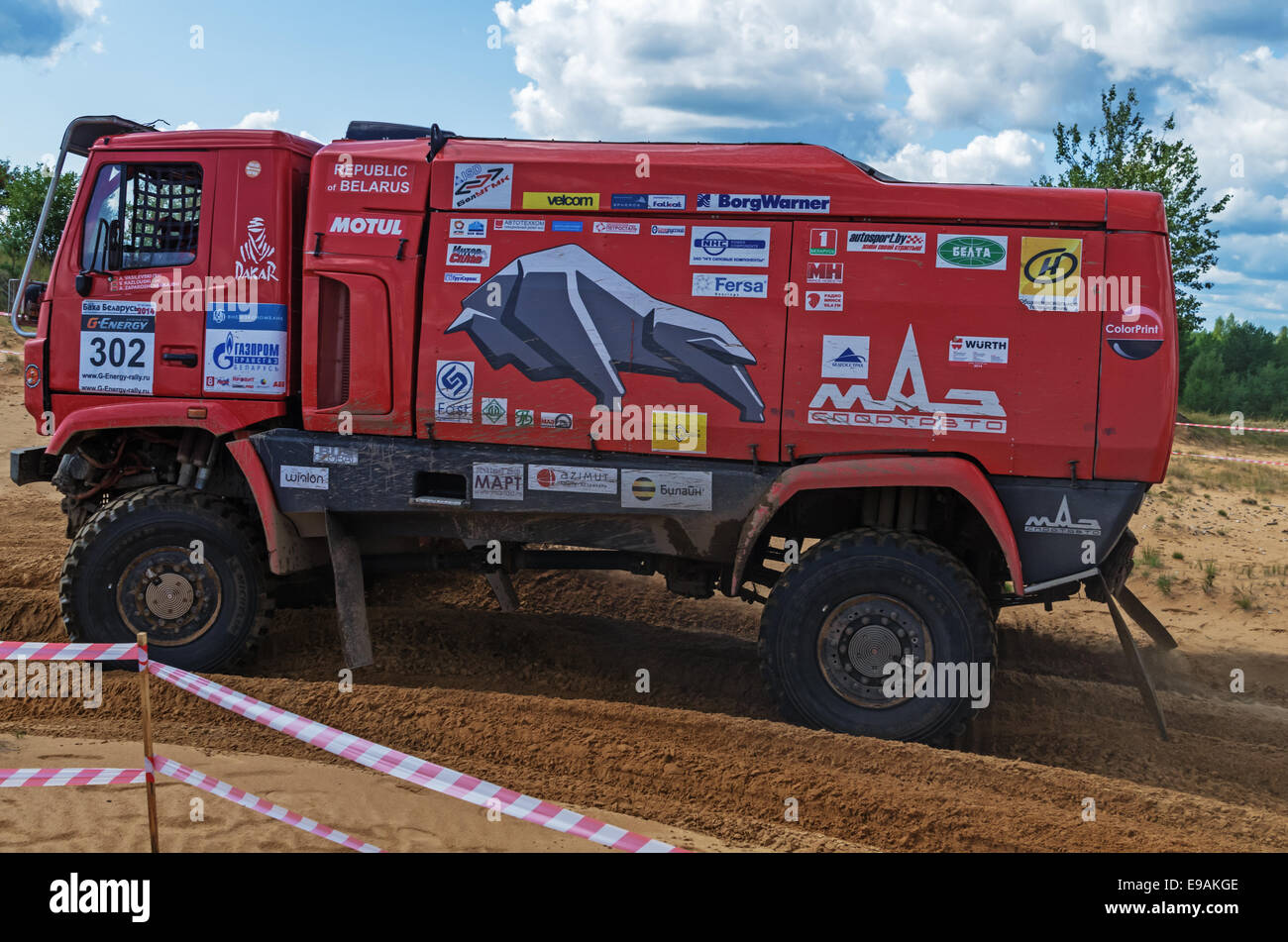 Races on a rally-raid on sandy dunes. Racing truck maz number 302 Stock ...