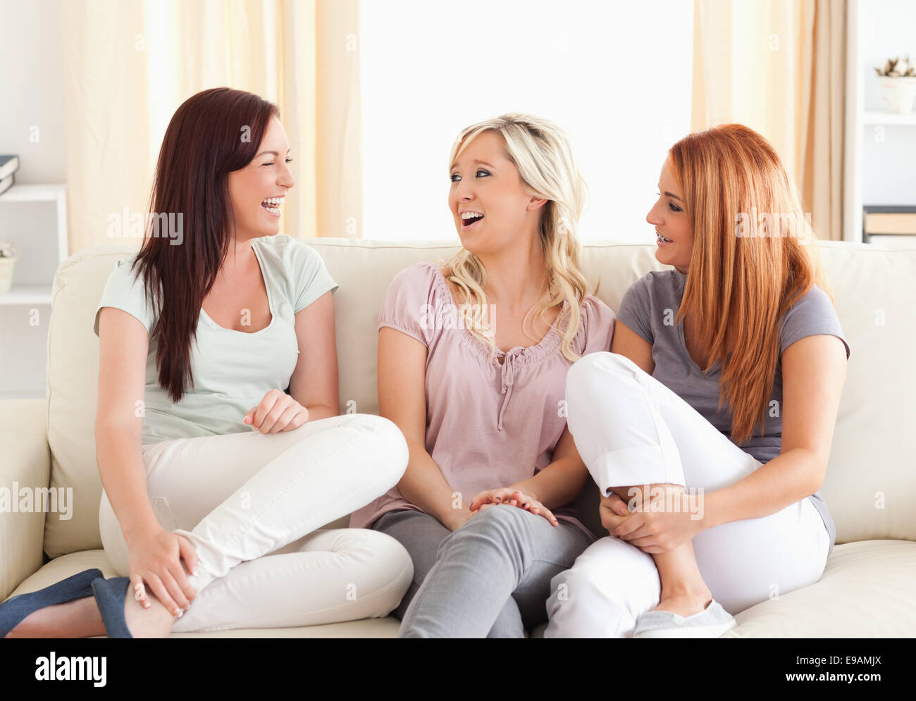 Charming friends lounging on a sofa Stock Photo - Alamy