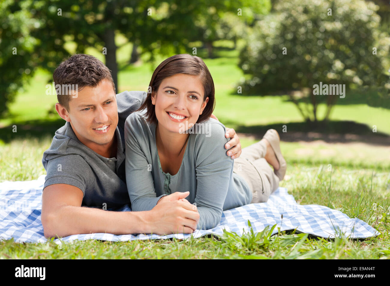 Couple lying down in the park Stock Photo - Alamy