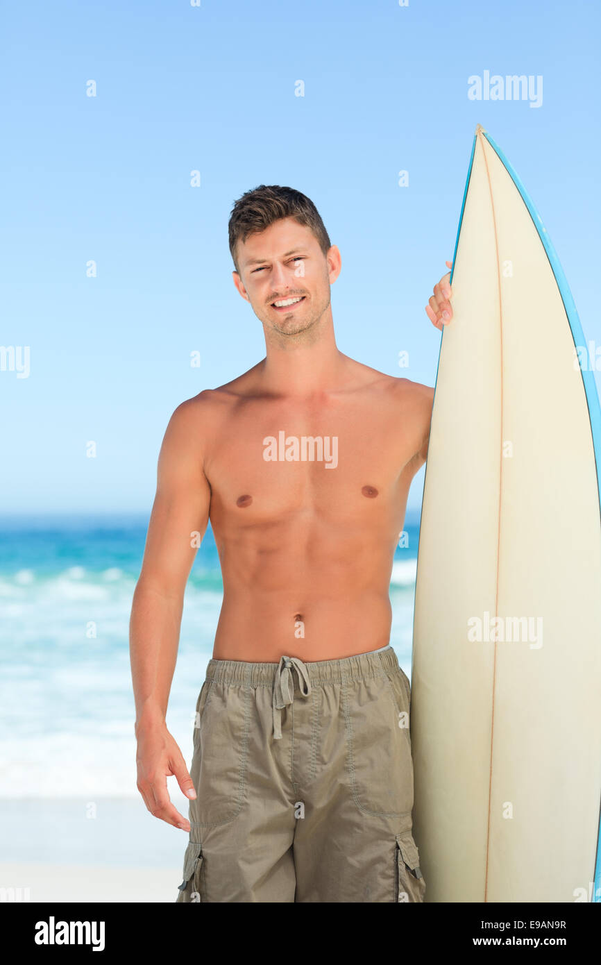 Handsome man with his surfboard Stock Photo - Alamy