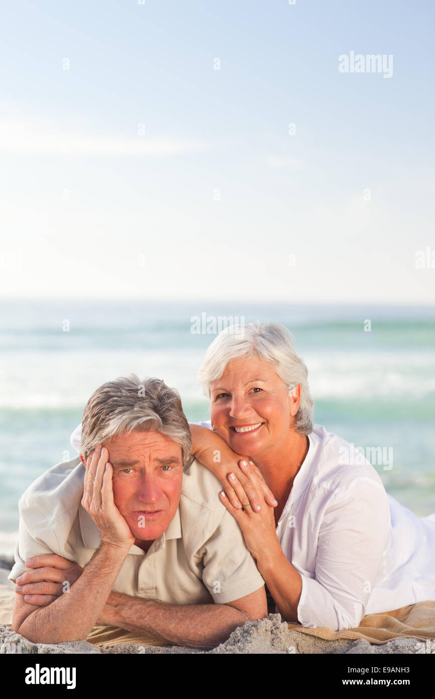 Elderly couple lying down on the beach Stock Photo - Alamy