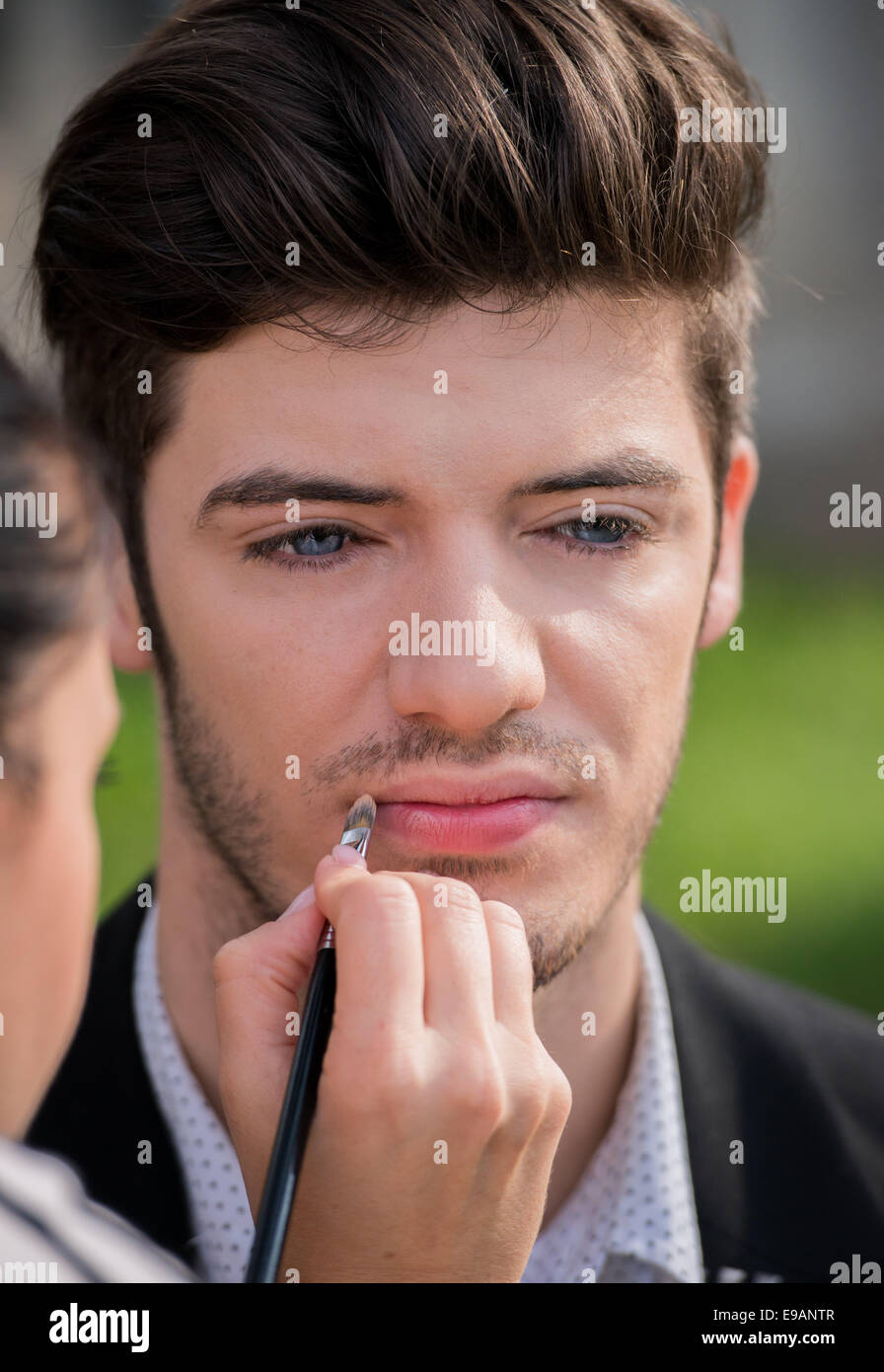 Attractive young man during a make-up session Stock Photo - Alamy