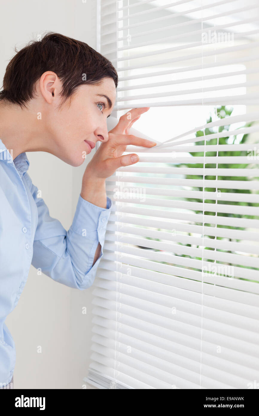 Cute woman peeking out a window Stock Photo - Alamy