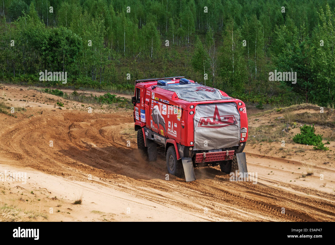 Races on a rally-raid on sandy dunes. Racing truck maz number 302 Stock ...
