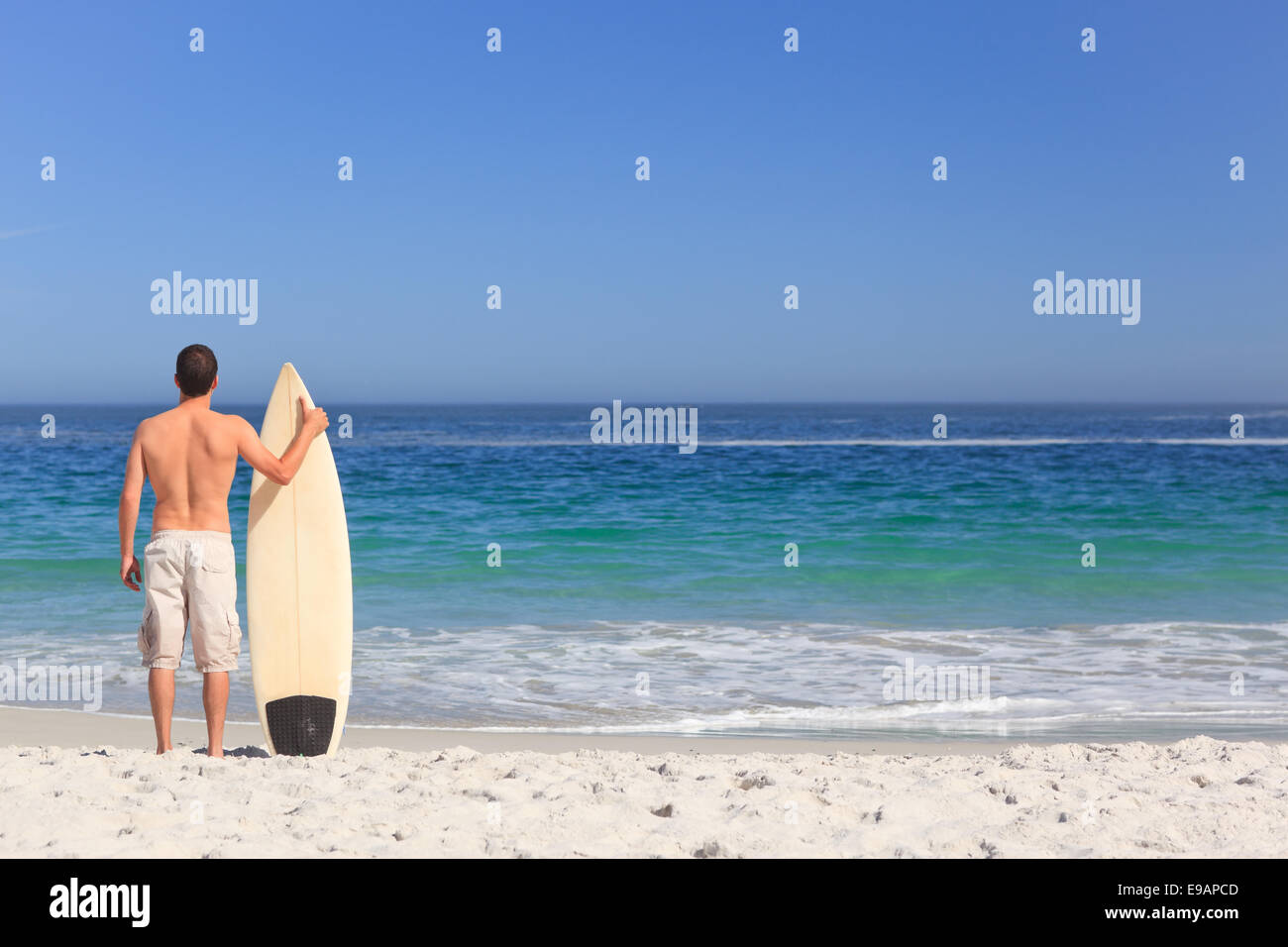 Man wirth his surfboard on the beach Stock Photo - Alamy