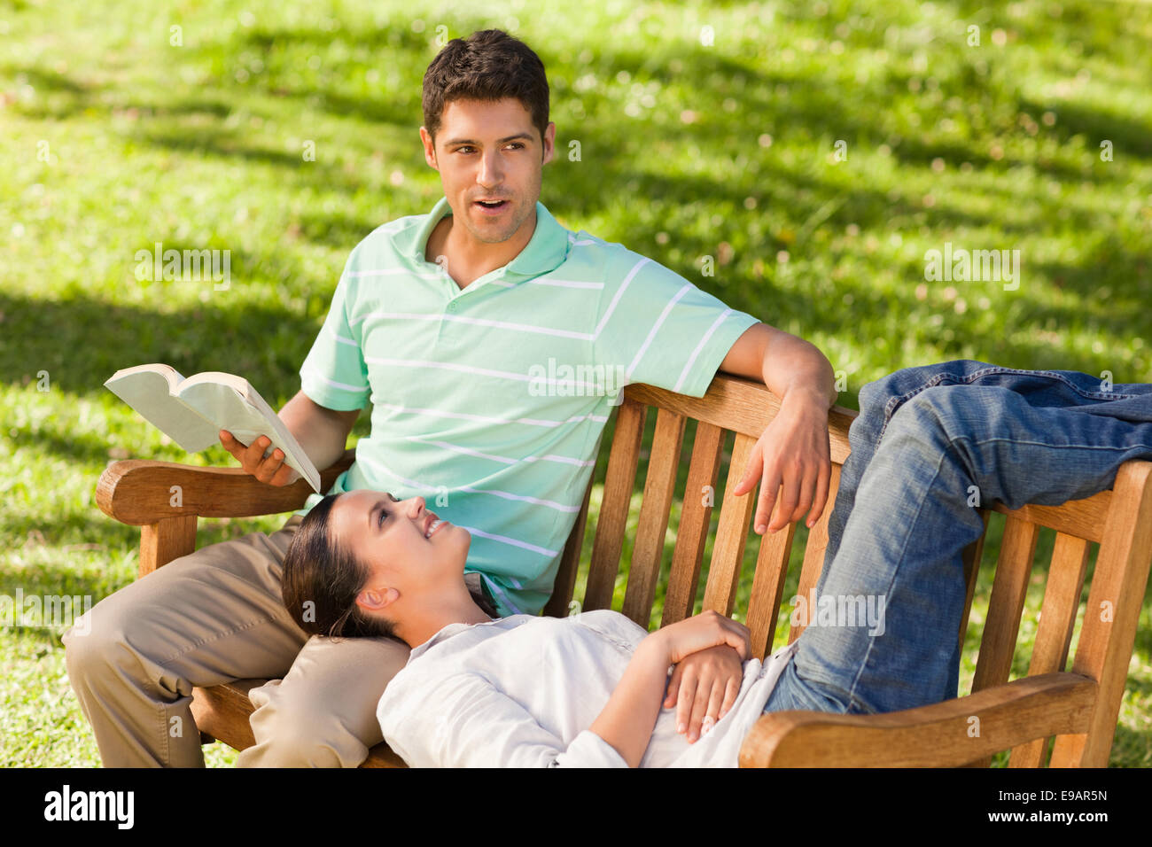 Man reading a book with his girlfriend Stock Photo - Alamy