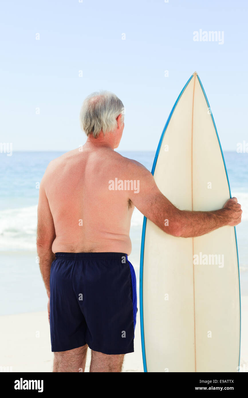 Retired man with his surfboard Stock Photo - Alamy