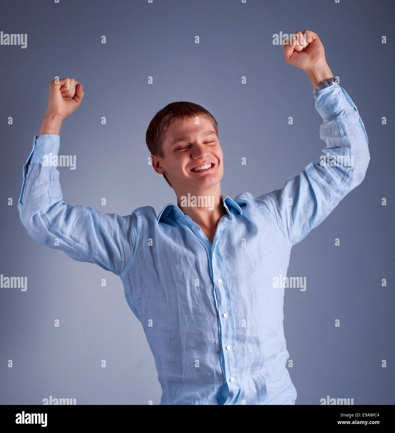 portrait of young happy man with raised hands Stock Photo - Alamy