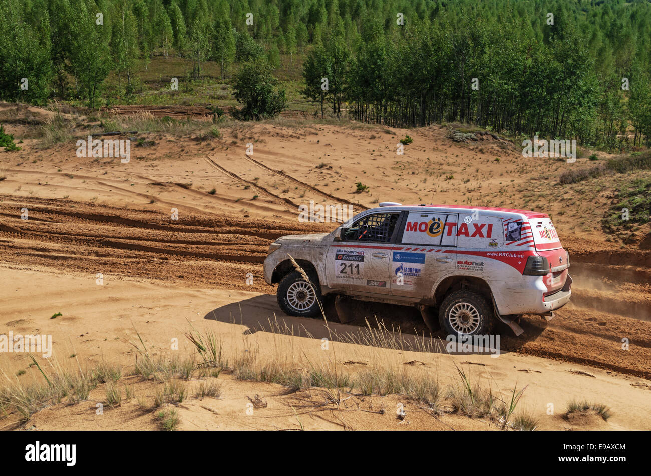 Races on a rally-raid on sandy dunes. Racing car number 211 Stock Photo ...