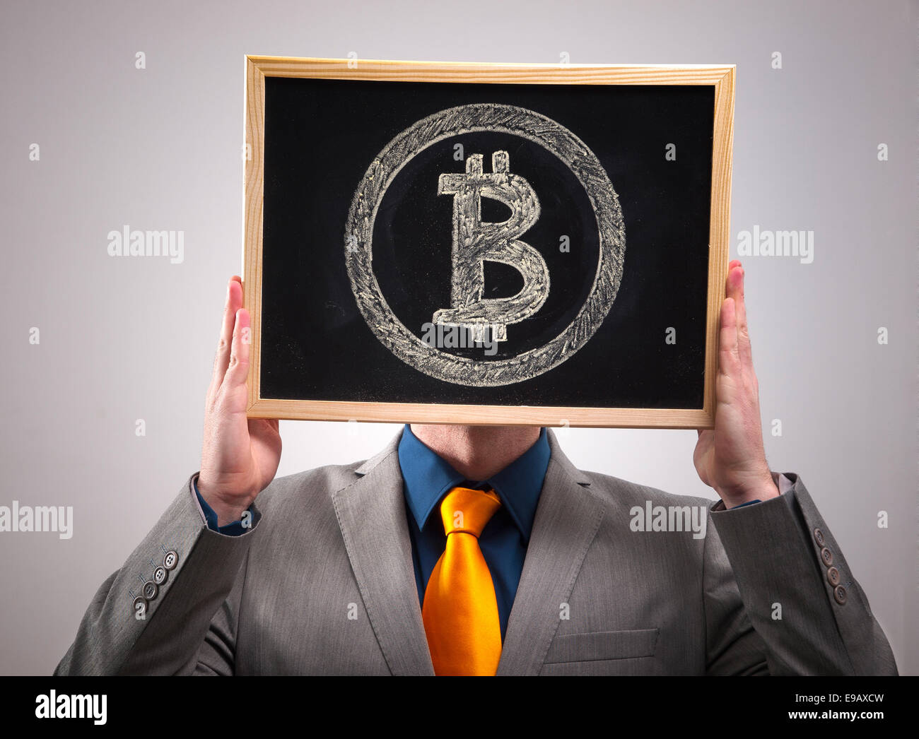 Businessman hiding his face behind bitcoin symbol and isolated on dark ...