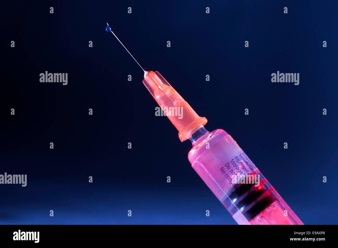 syringe on blue background Stock Photo - Alamy