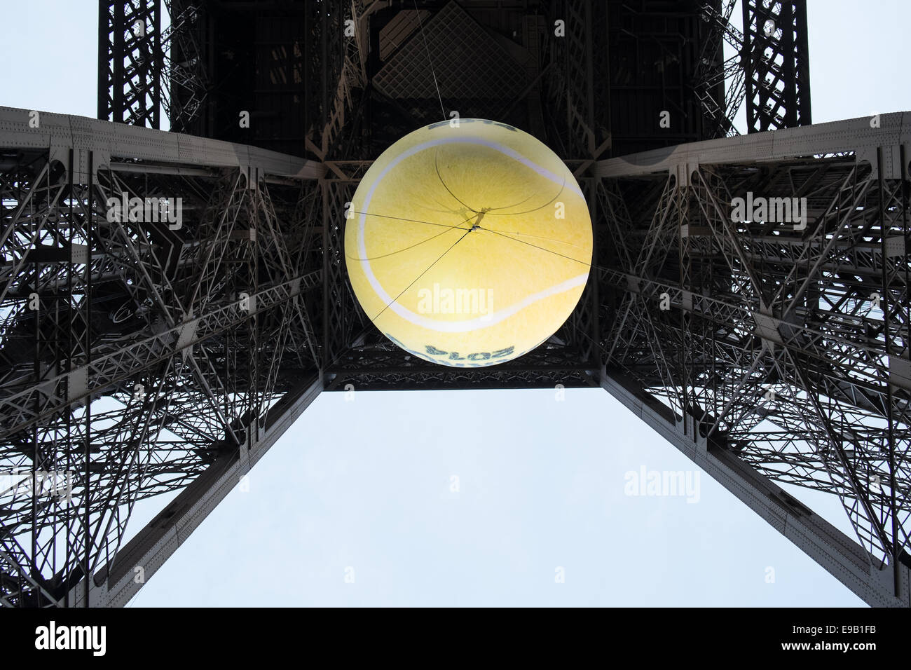 Eiffel Tower with a giant,tennis ball hanging above the first platform ...