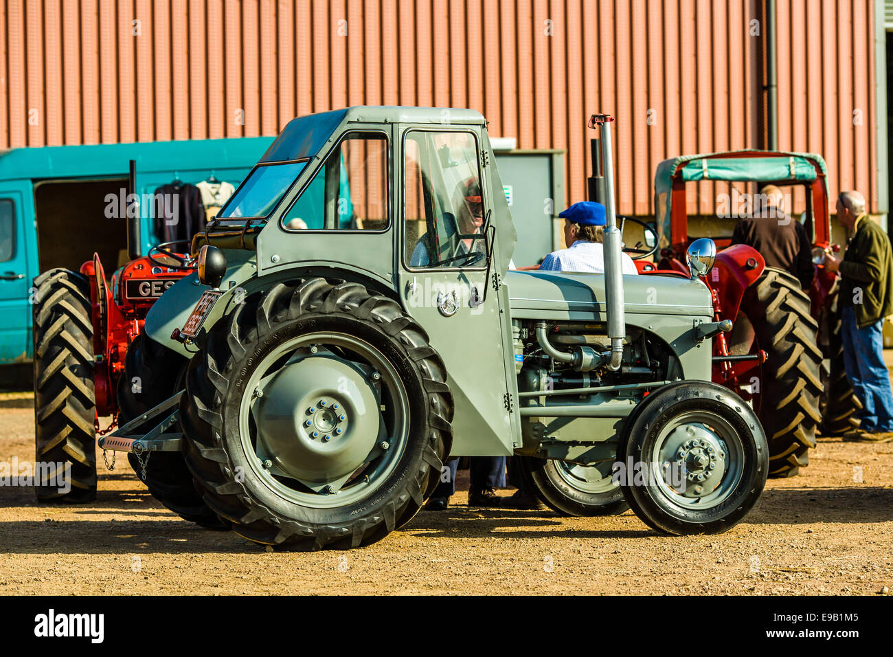 Green vintage tractor with safety weather cabin in yard with other ...