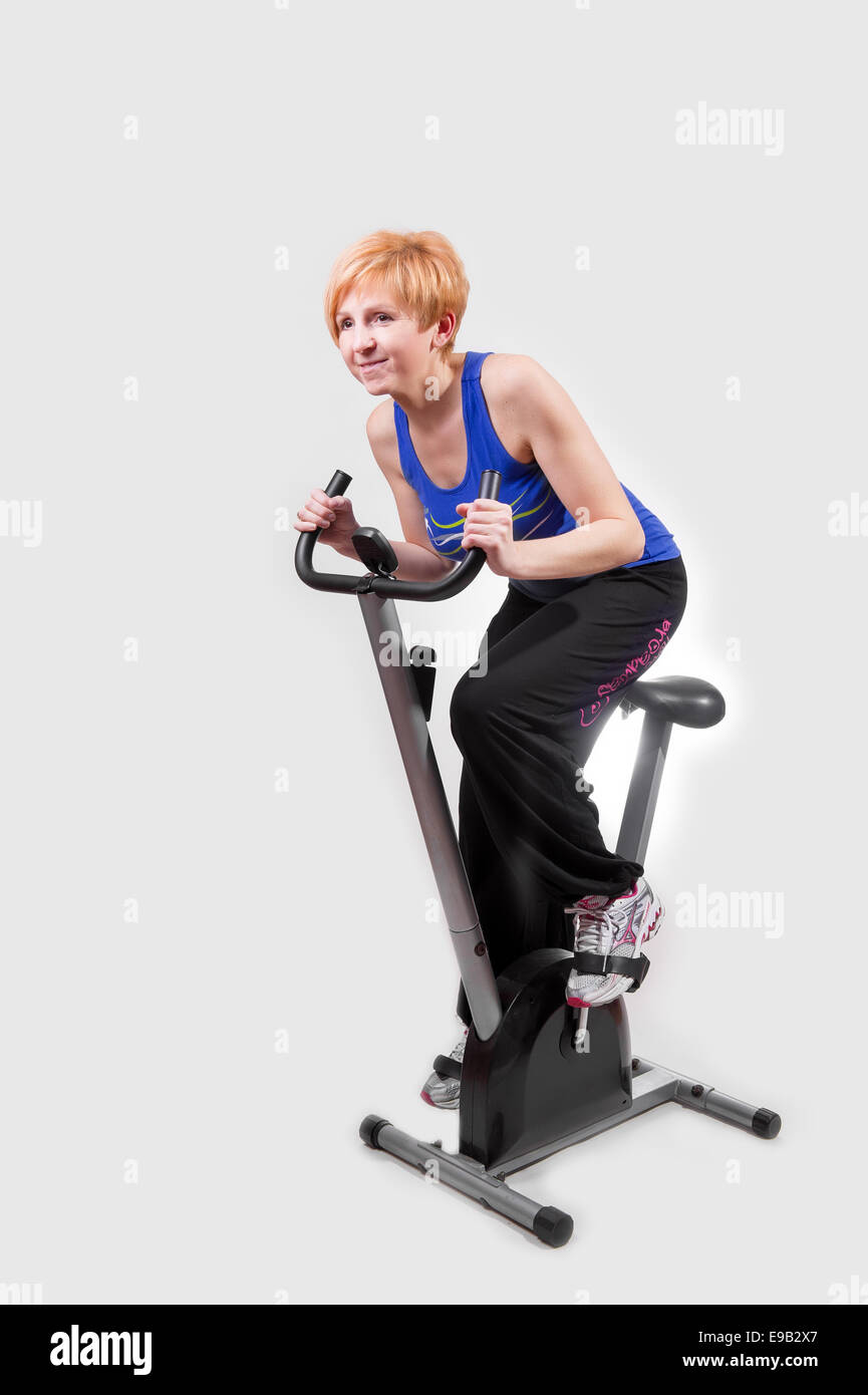 Woman doing sports on exercise bike Stock Photo - Alamy