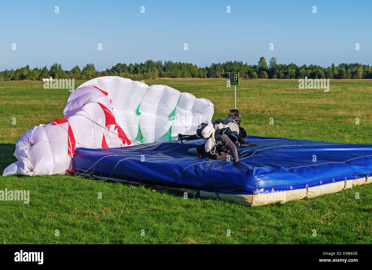 Parachutists - 2014. The girl skydiver landing under white parachute ...