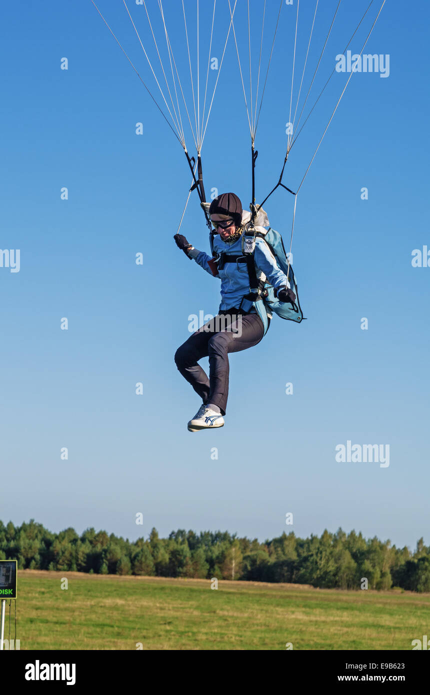Parachutists - 2014. The girl skydiver landing under white parachute ...