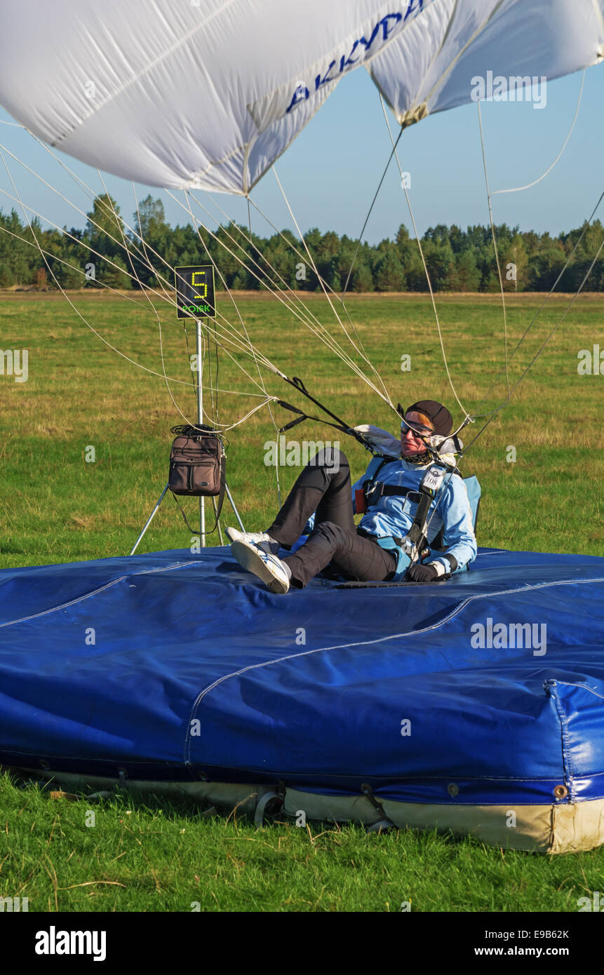 Parachutists - 2014. The girl skydiver landing under white parachute ...