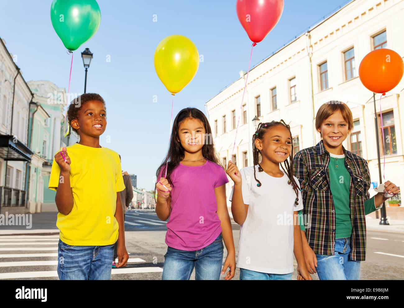 Team of kids with colorful balloons standing Stock Photo - Alamy