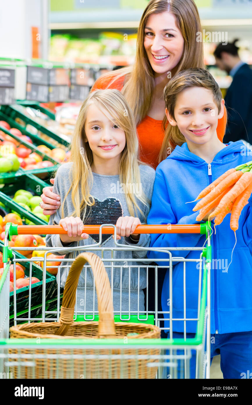 Family selecting fruits and vegetables while grocery shopping in ...