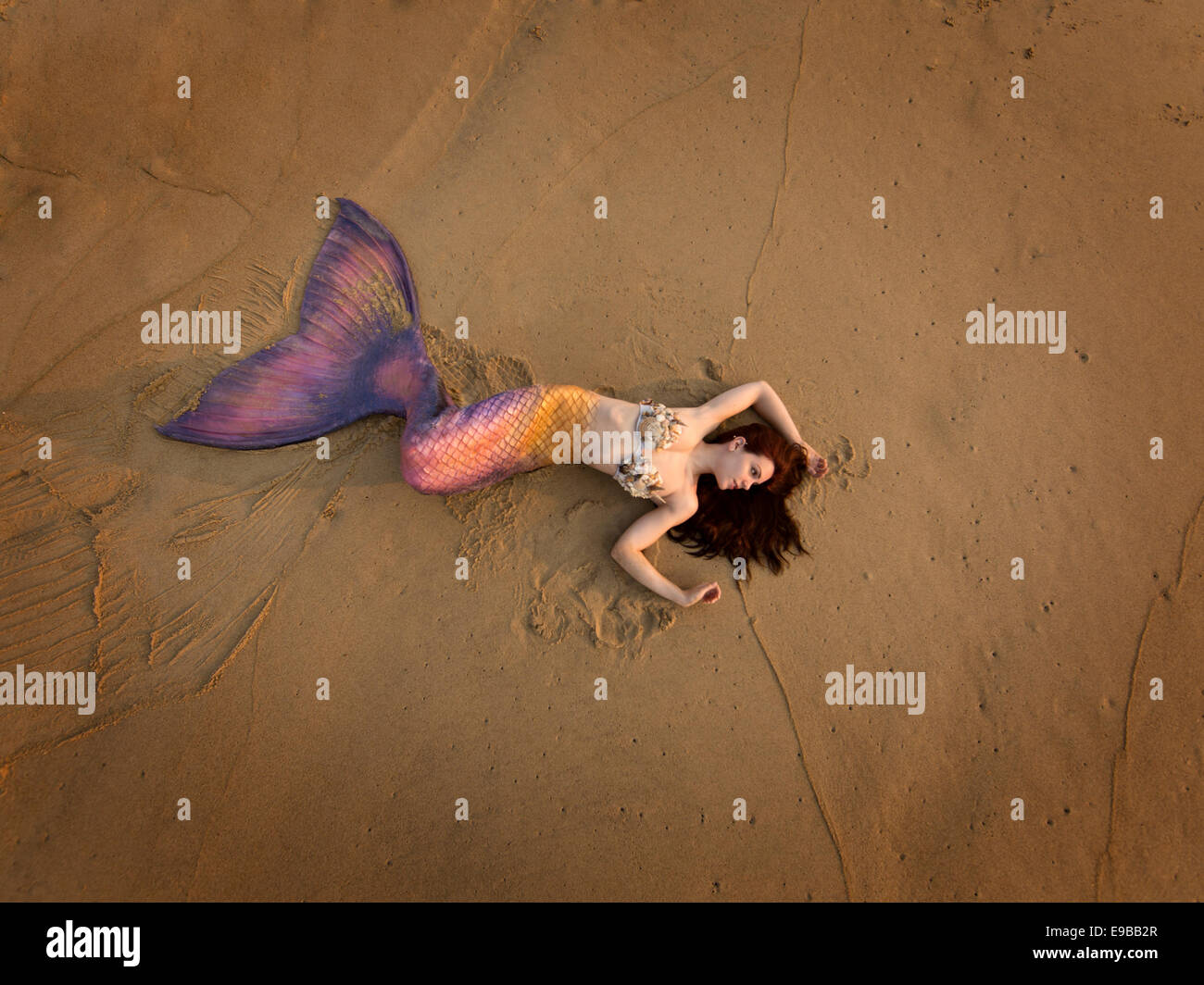 Mermaid Laying On The Beach During Sunrise In Virginia Beach Stock