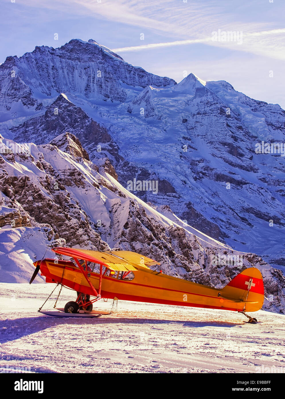 Yellow red airplane at the mountain airfield in swiss alps in front of ...