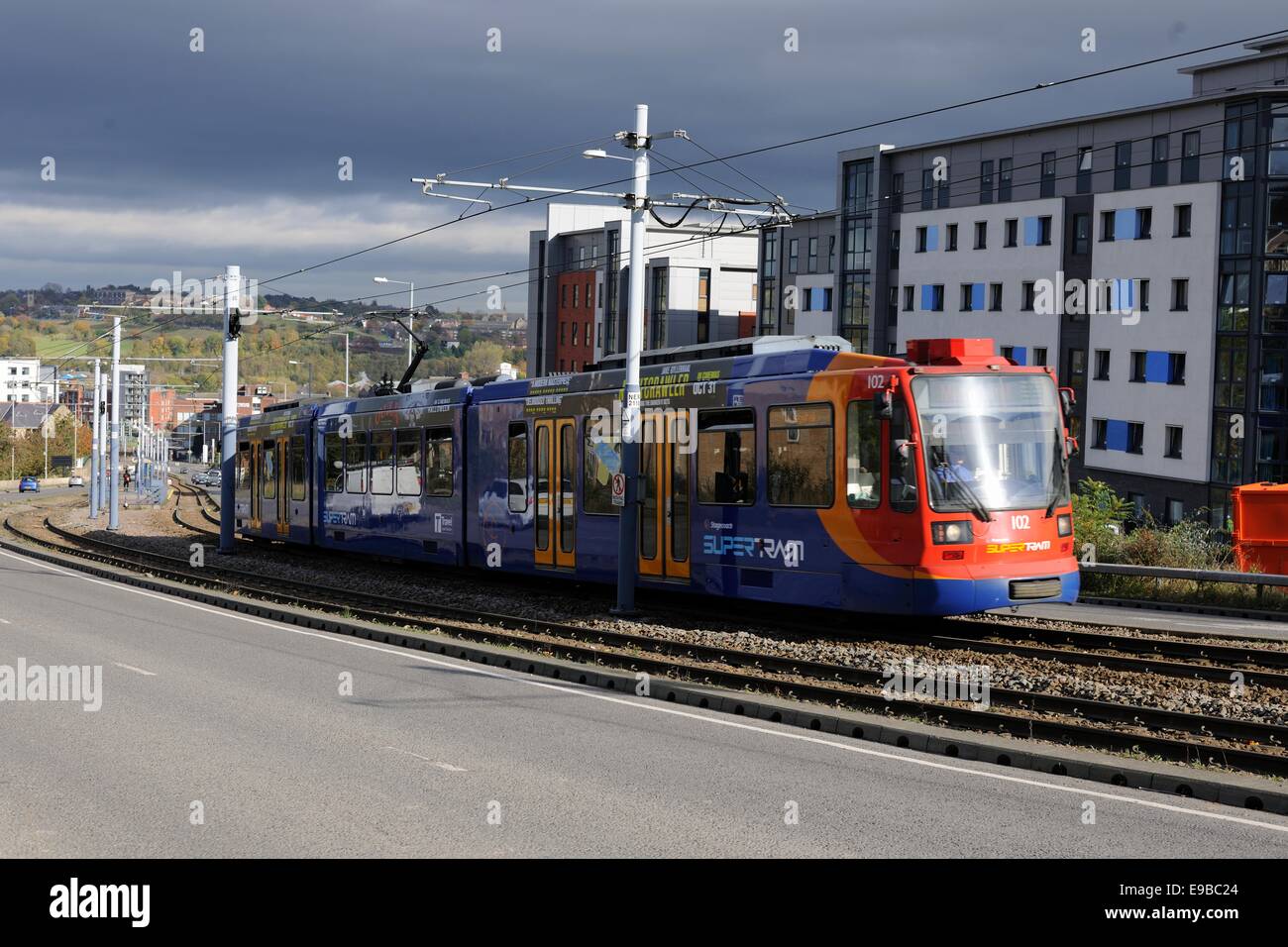 Urban tram climbing a hill with modern apartment blocks behind Stock ...