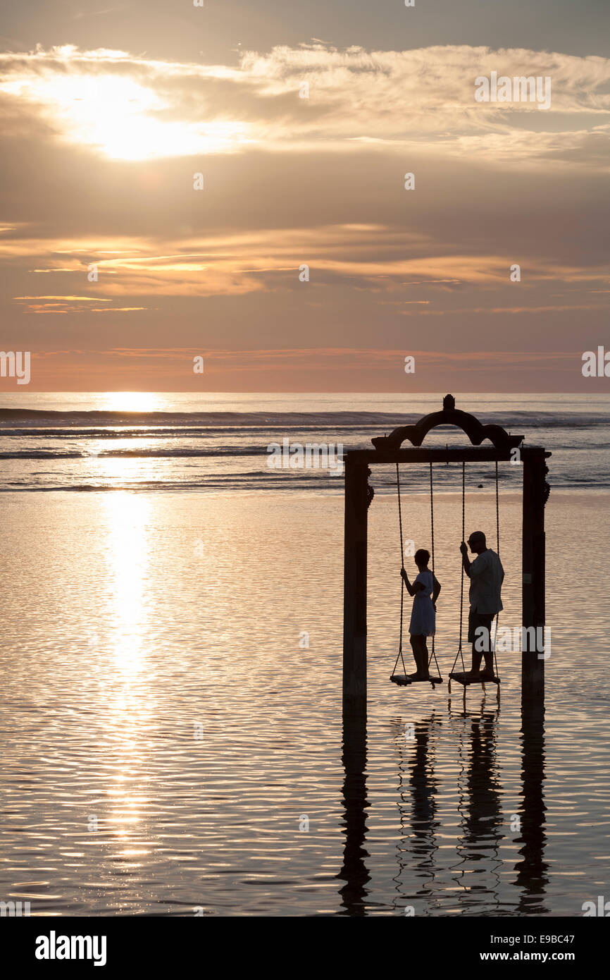 Two people watching sunset on sea swing in "Indian Ocean", "Gili ...