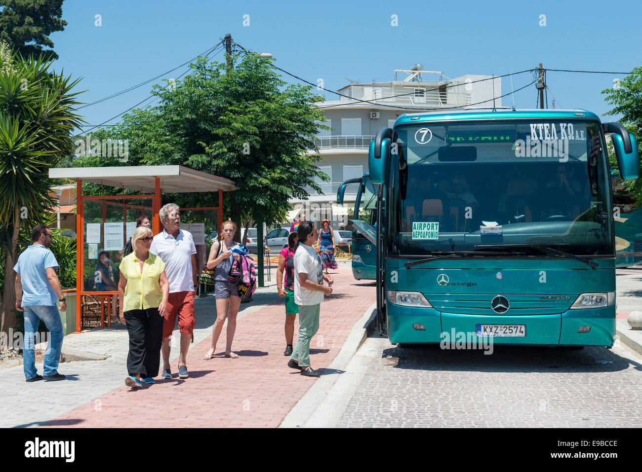 Passengers enter a bus at a bus stop in the town of Kos, island of Kos ...