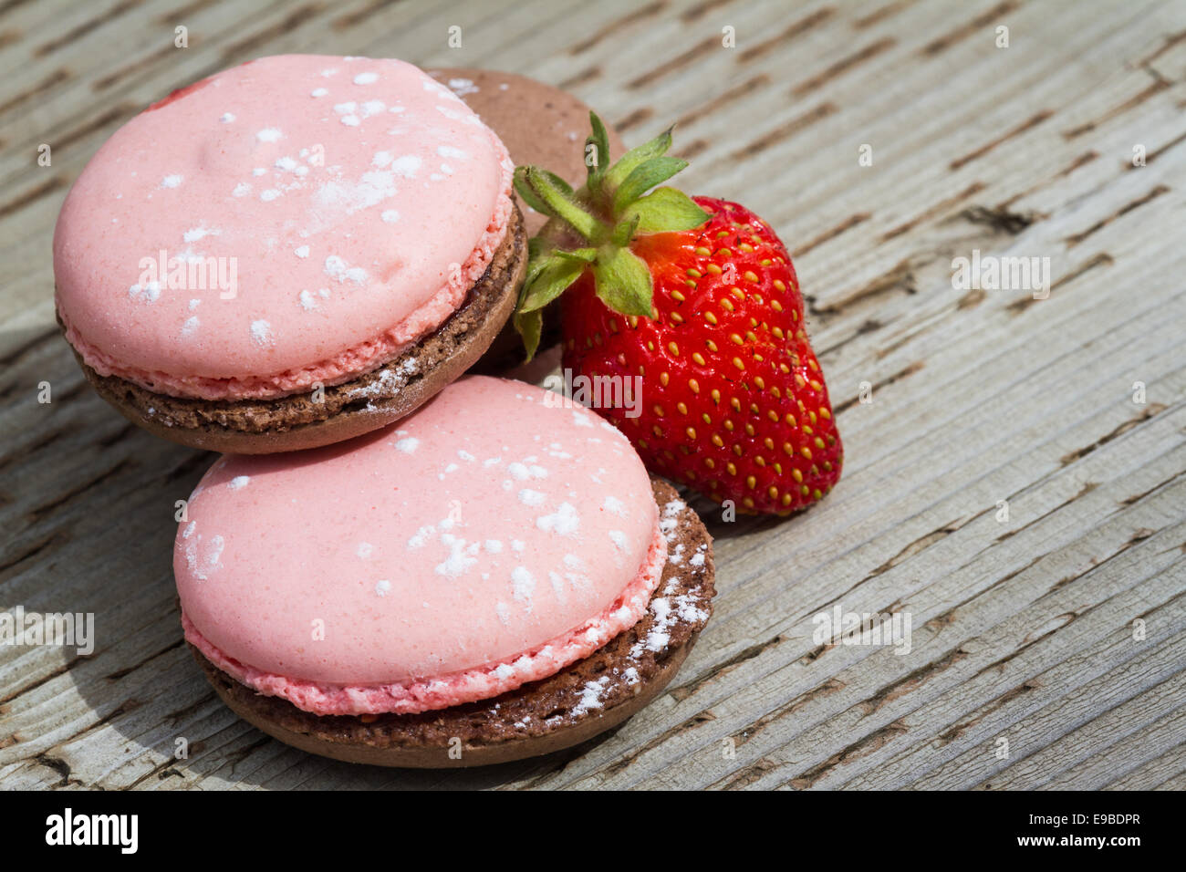 delicious french macaroons with a fresh strawberry served on a rustic ...