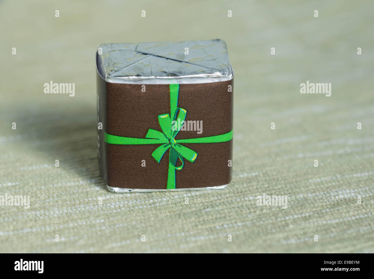 Chocolate in a wrapper with a bow close up Stock Photo - Alamy
