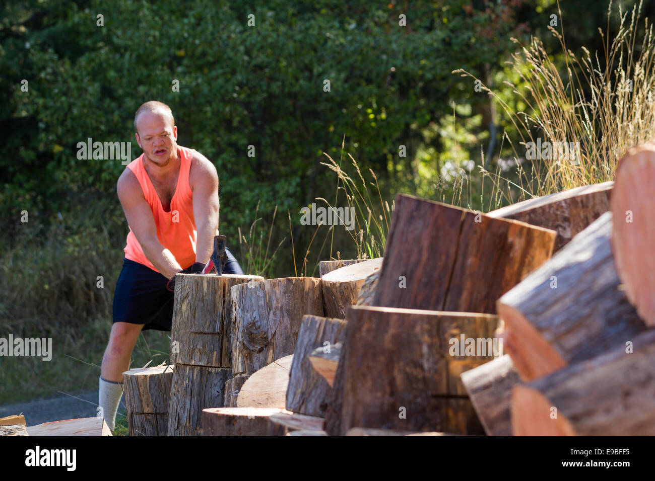 young man outdoors splitting wood by hand for the wirer Stock Photo - Alamy