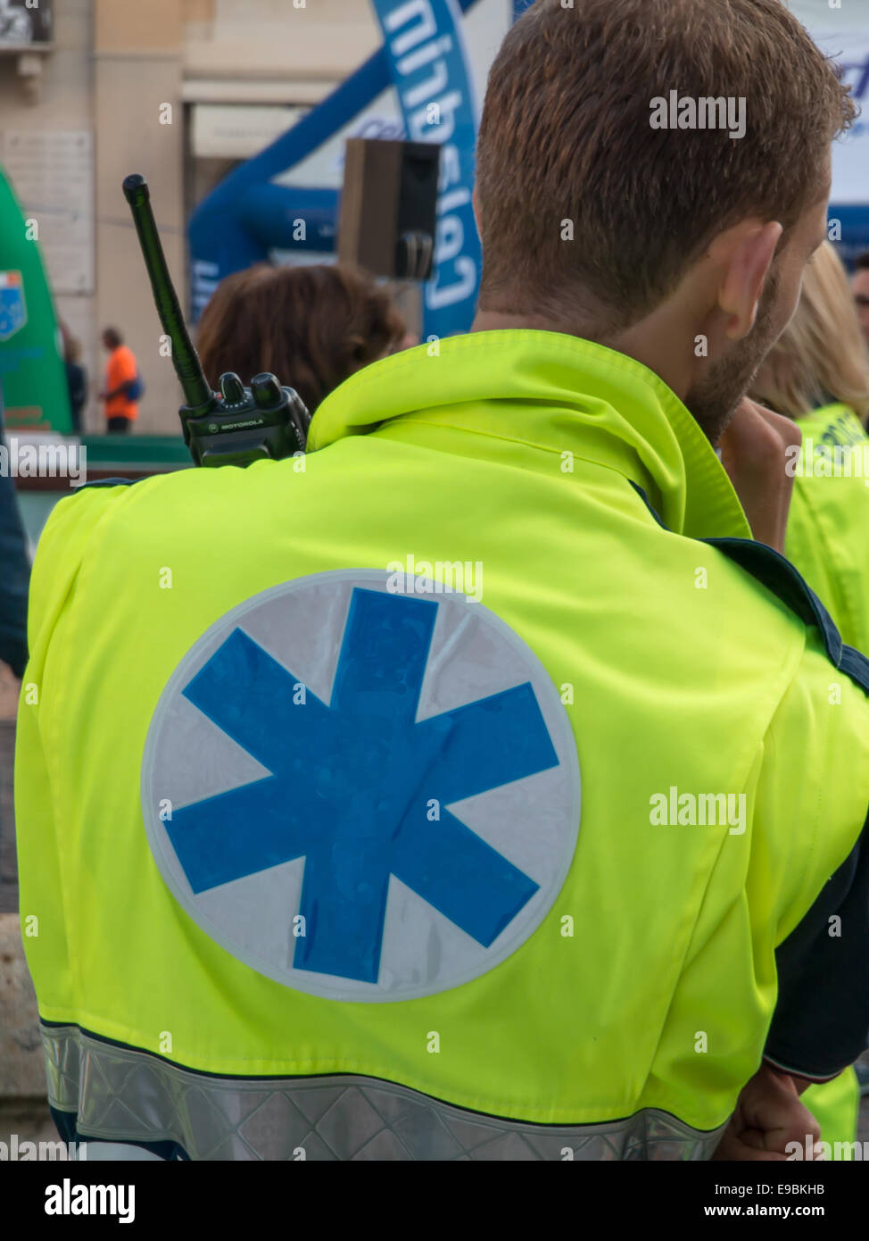 Paramedic with radio equipment wait for call; blue and yellow dressed ...
