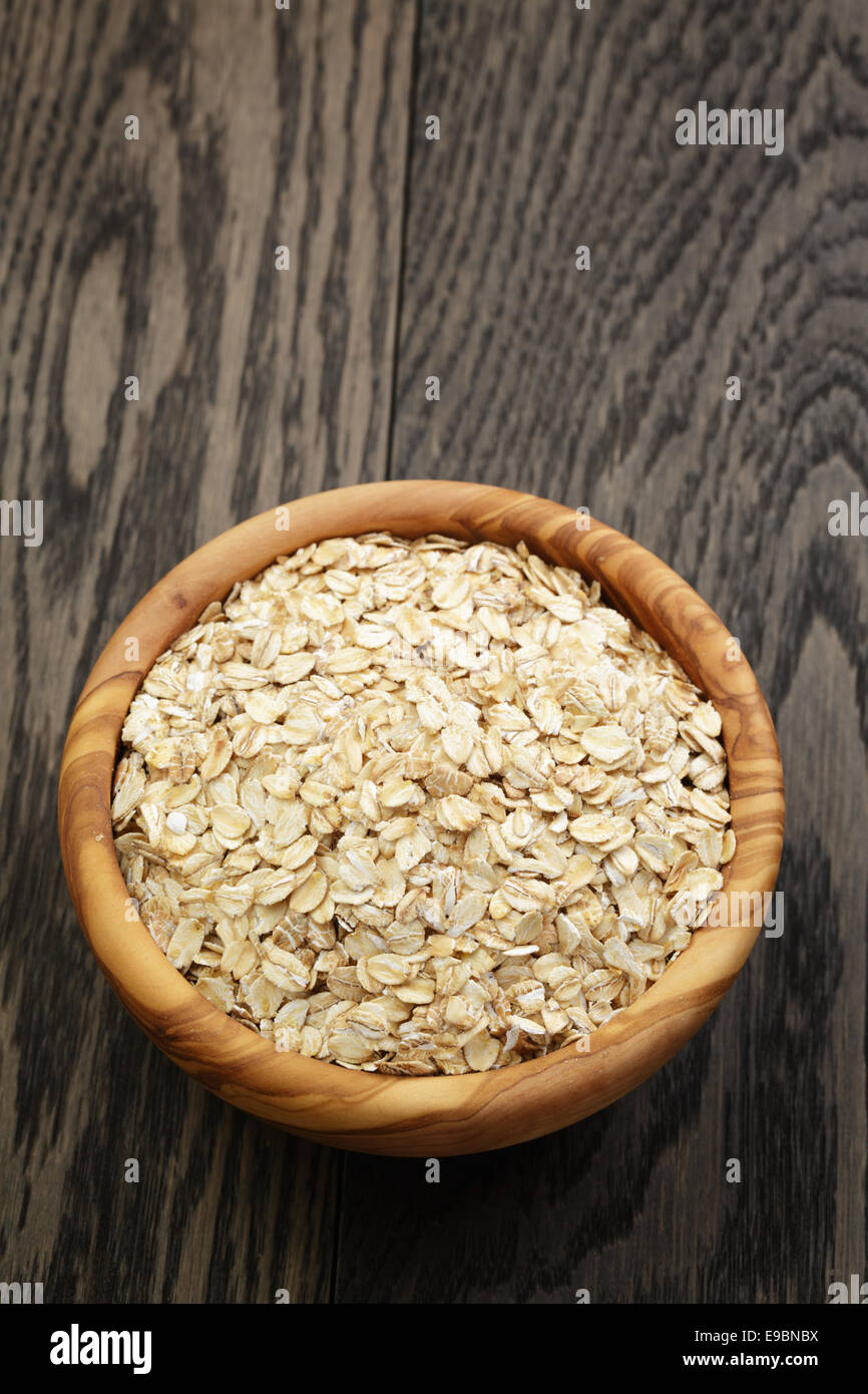 oat flakes in wood bowl on oak table, rustic style Stock Photo - Alamy